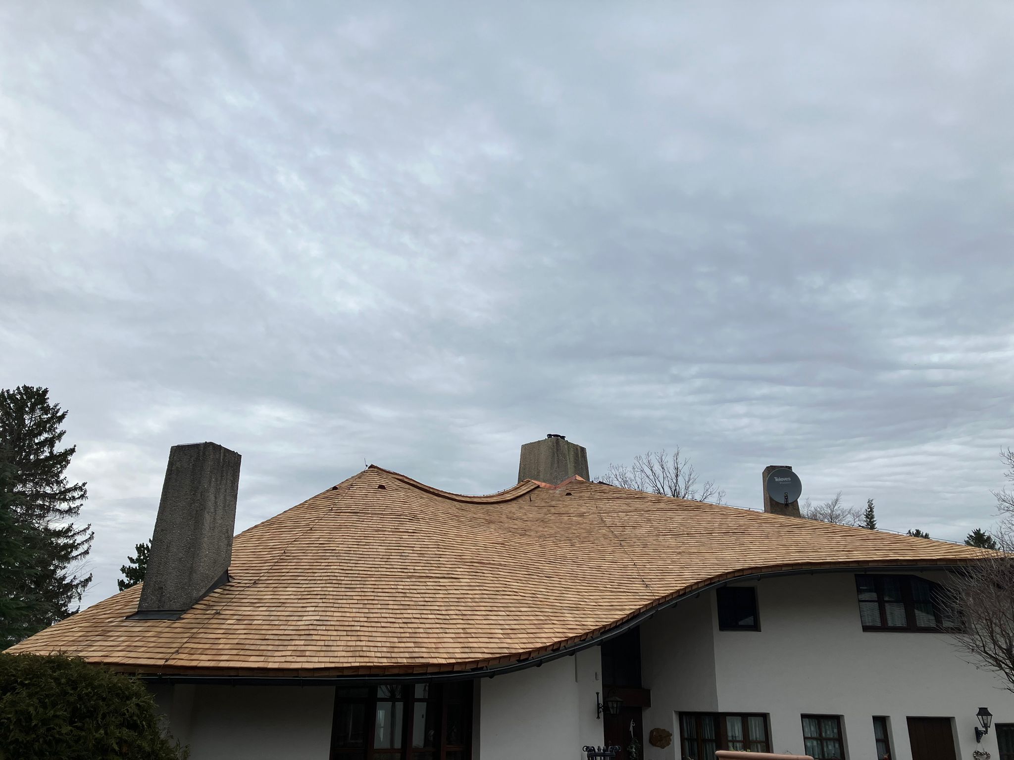 Wohnhaus am Ammersee - Dächer und Fassaden mit Holzschindeln gedeckt